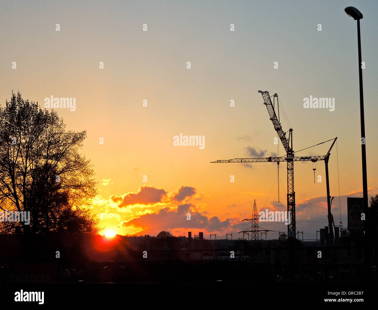 Sunset Over Building Site With Cranes Stock Photo - Alamy