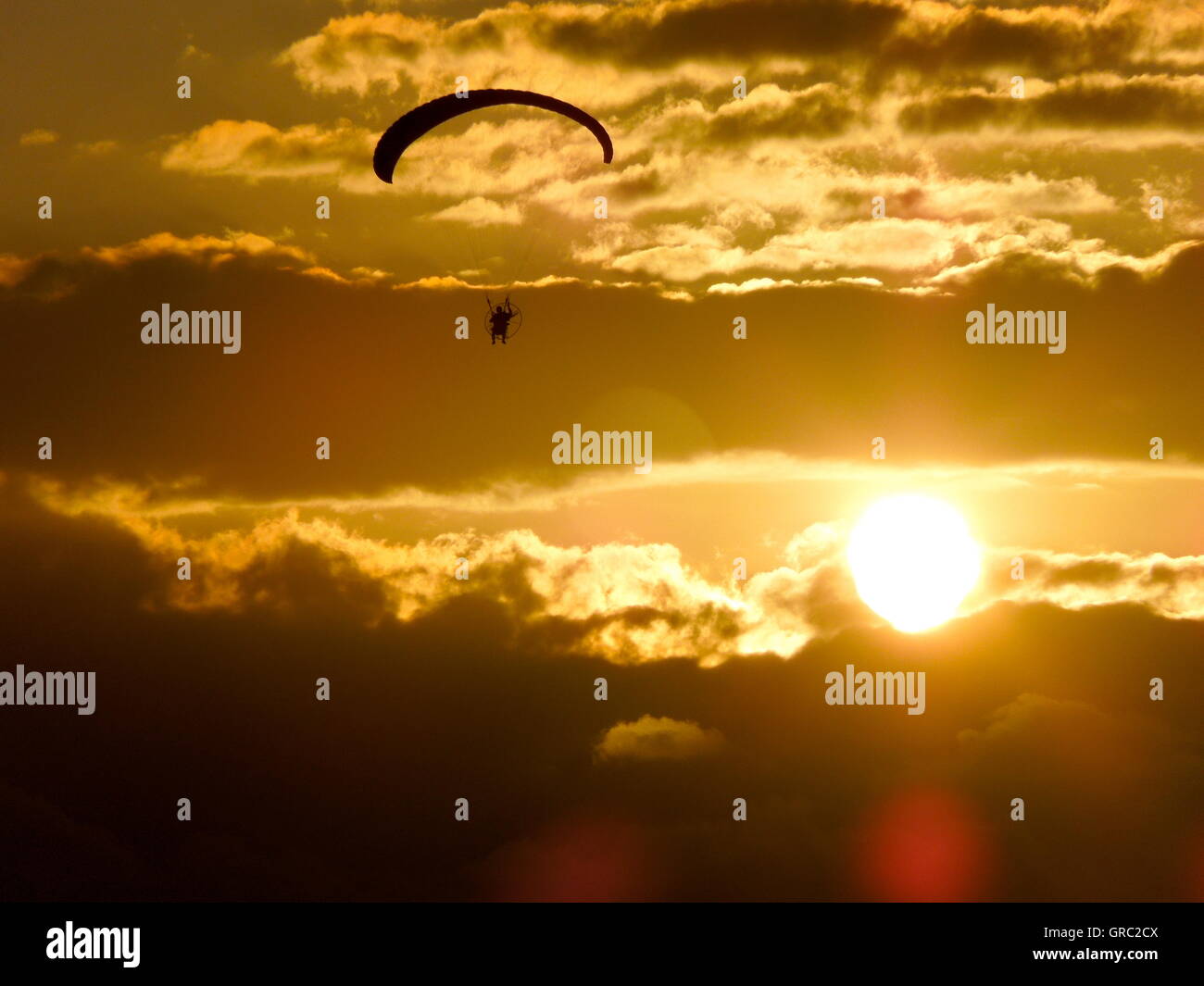 Flying A Paraglider At Sunset Stock Photo - Alamy