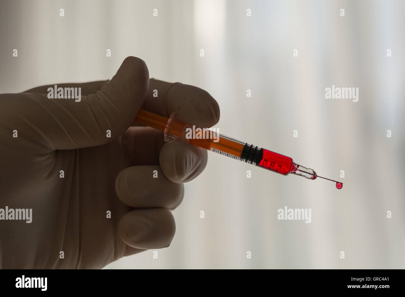Person With Syringe, Drop Hanging On The Needle Stock Photo - Alamy