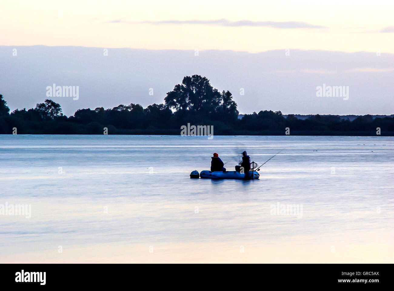 Angler Angling In The Boat Stock Photo - Alamy
