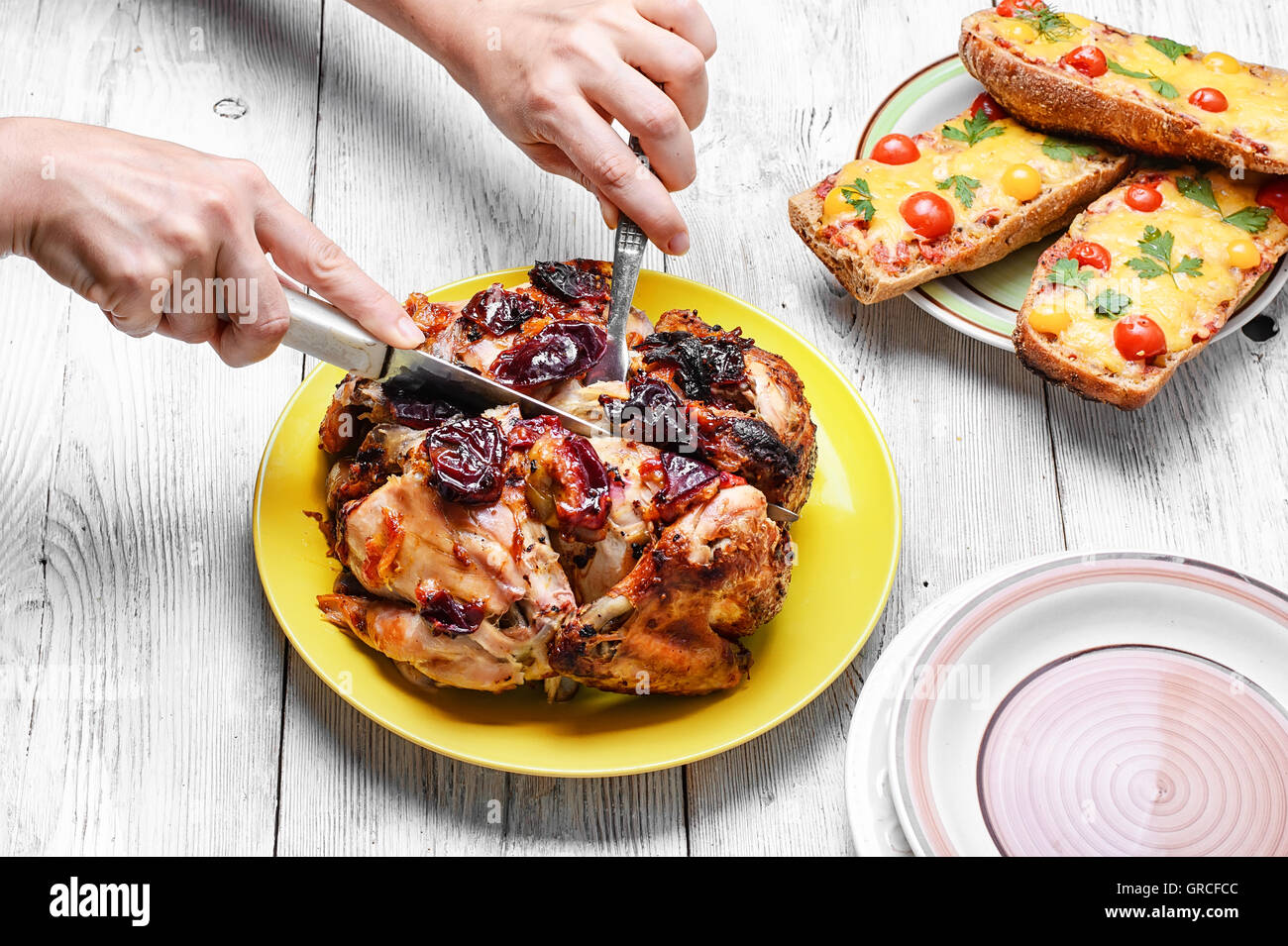 Hands with knife and fork,cutting up baked chicken Stock Photo - Alamy