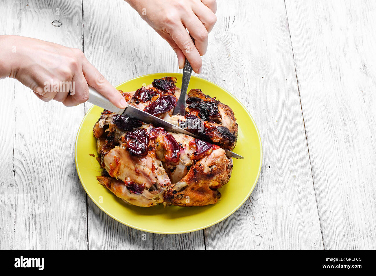 Hands with knife and fork,cutting up baked chicken Stock Photo - Alamy