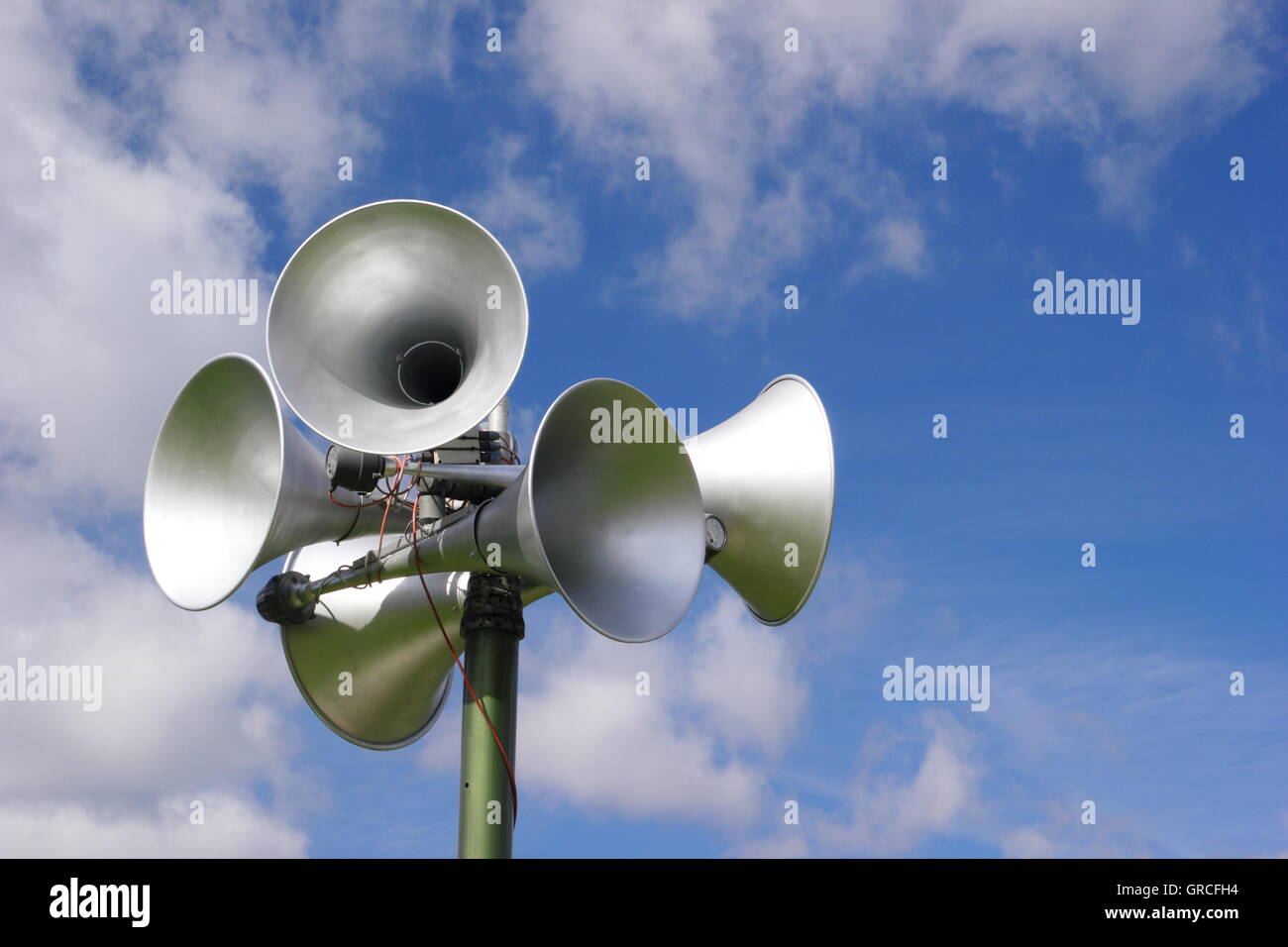 Loud hailers against a blue sky on a cloudy day with bright sunny ...