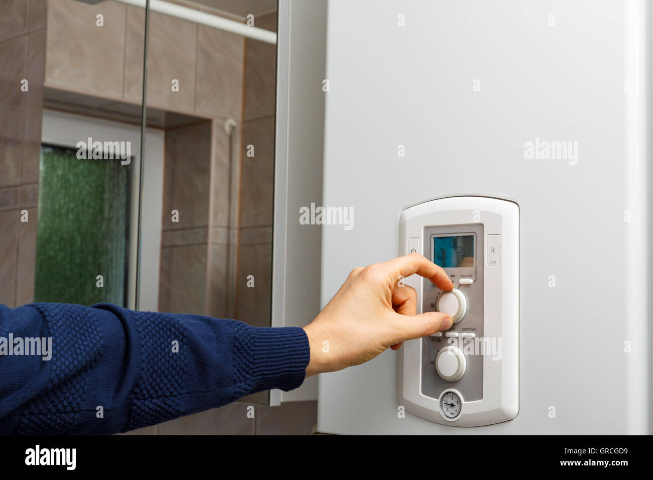 Men hand setting the temperature on control panel of DHW or central ...