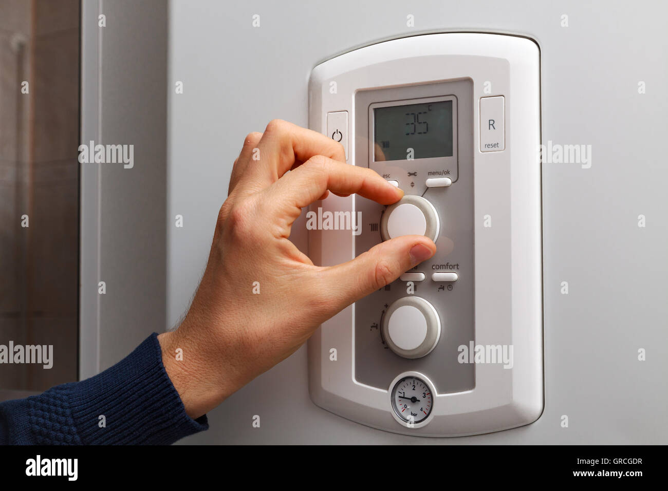 Men hand regulate low temperature on 35 degree in control panel of ...