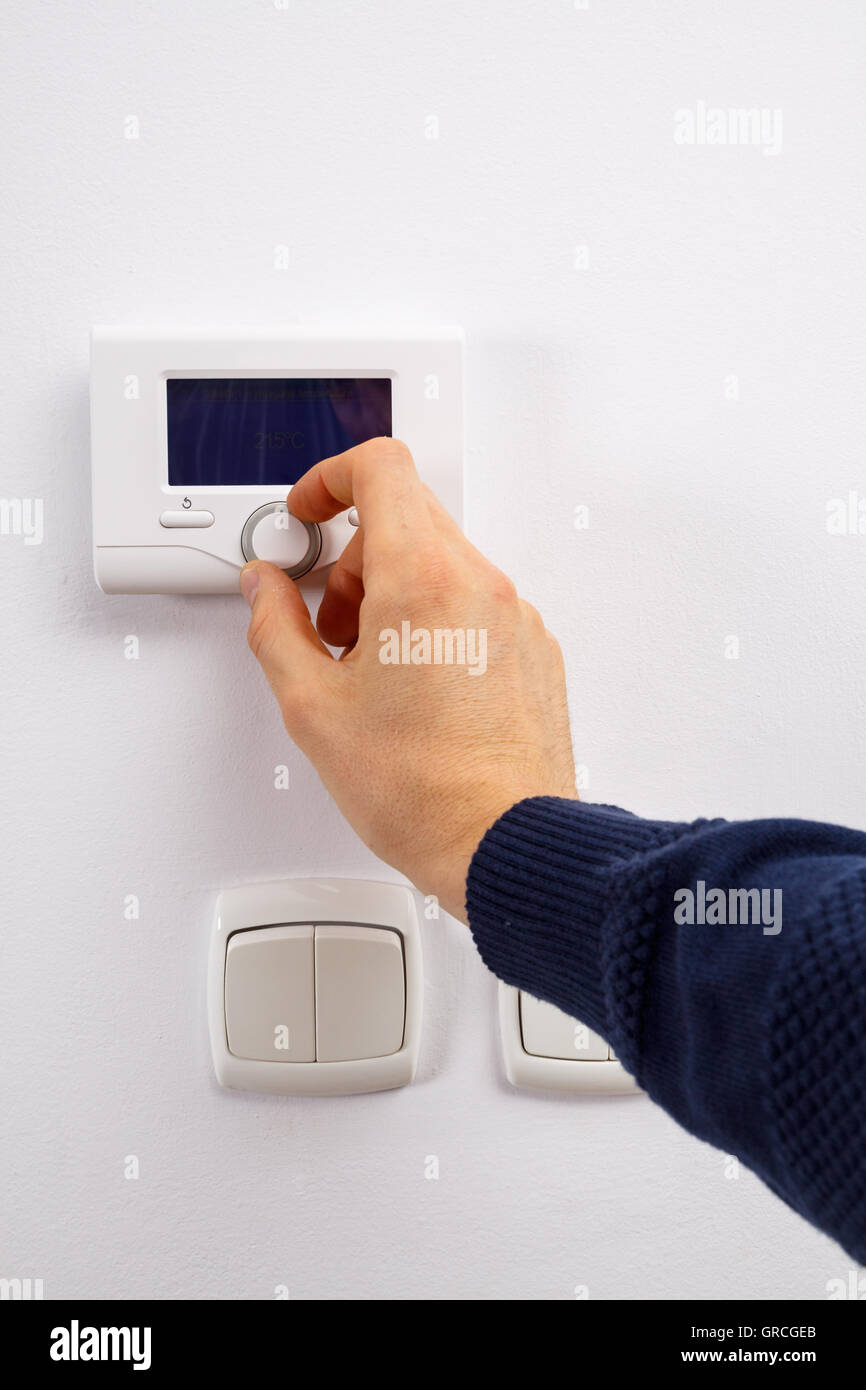 Men hand setting the temperature on control panel of DHW or central ...