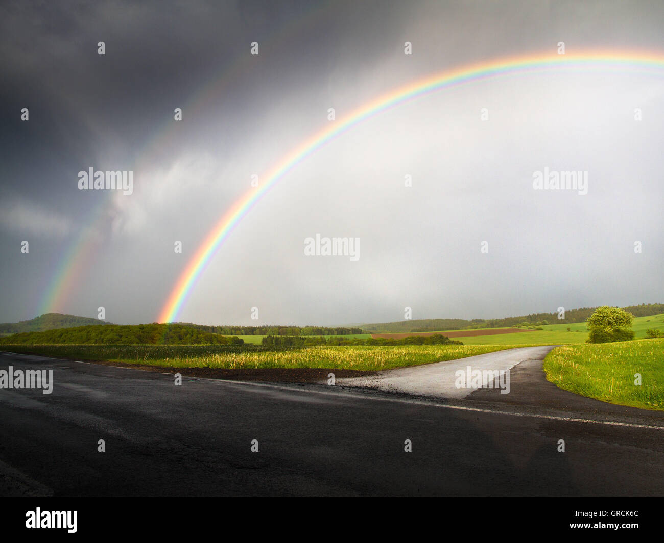 Rainbow Over Landscape With Light Show And Street Stock Photo - Alamy