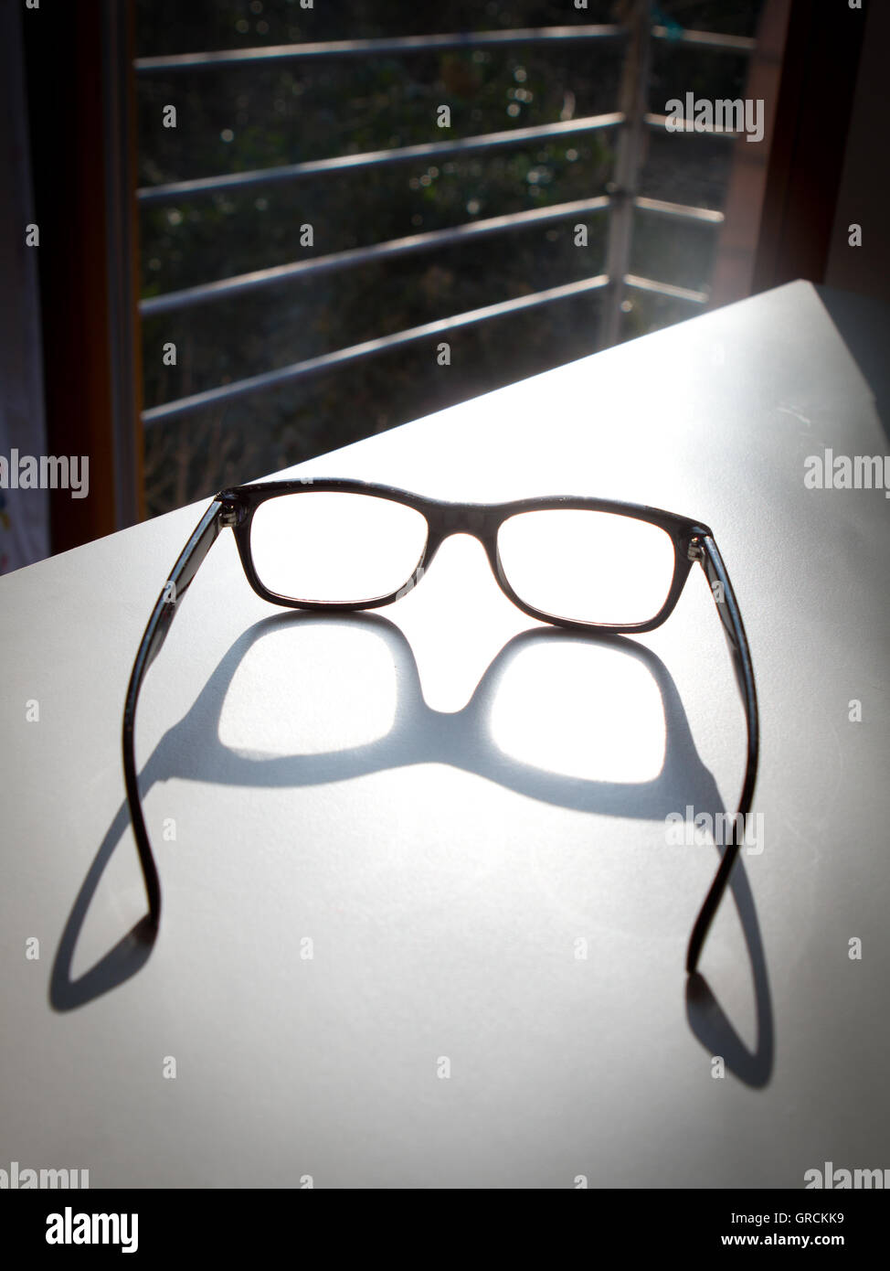 Glasses In The Sunlight On Desk Stock Photo - Alamy