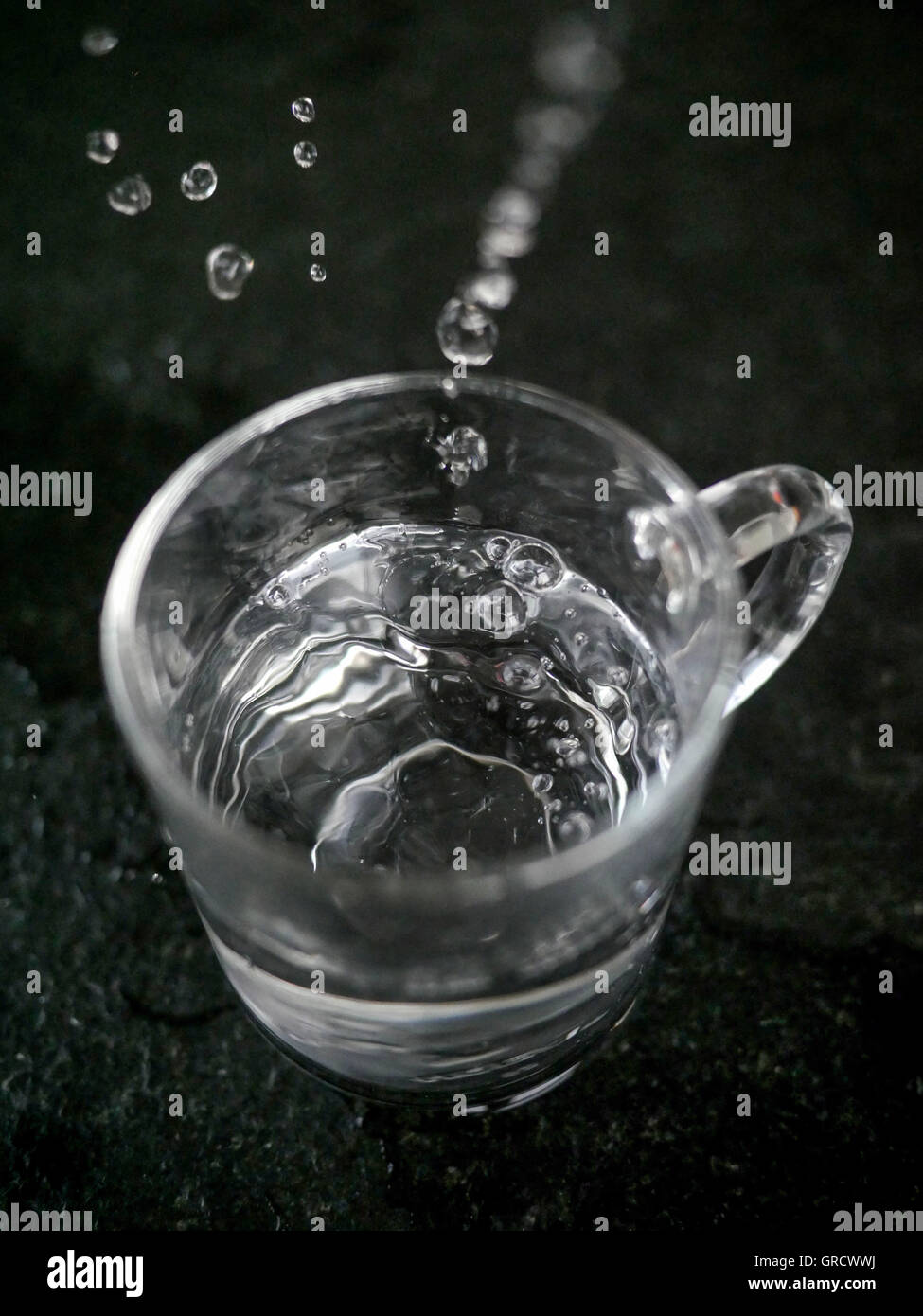 Drops Of Water Falling Into A Water Glass Stock Photo - Alamy