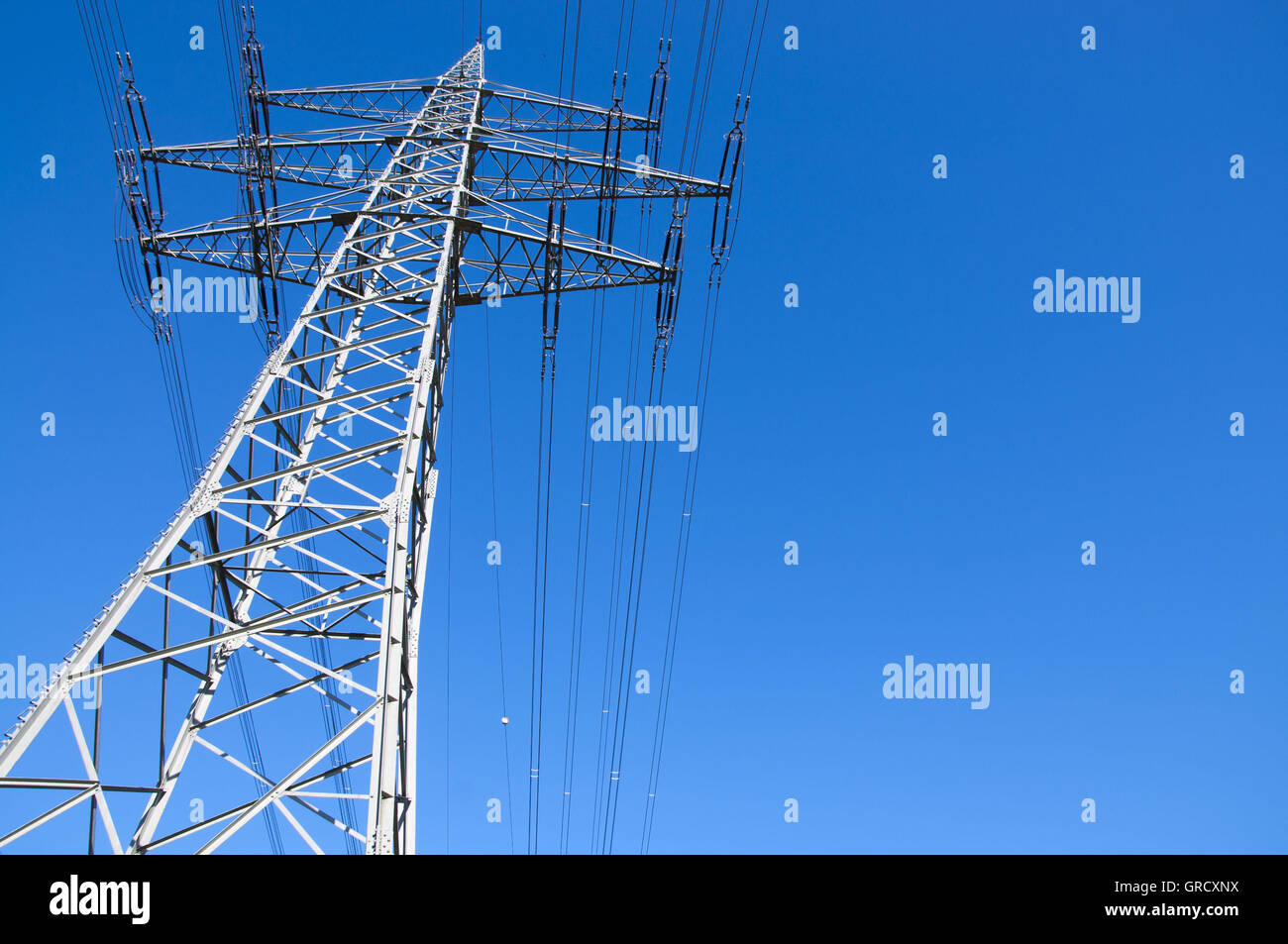 A Pylon In The Bright Blue Sky Seen From Below Stock Photo - Alamy
