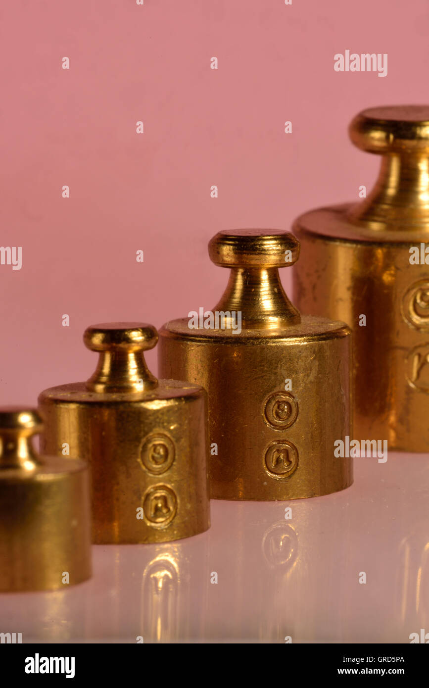 Weights Of Brass With Red Background Stock Photo - Alamy