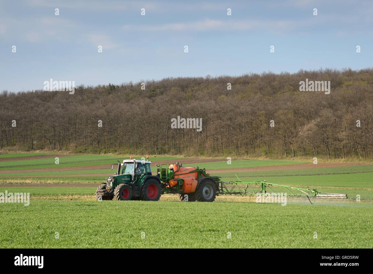 Farmer Spraying Pesticides With Green Tractor On A Field Stock Photo ...