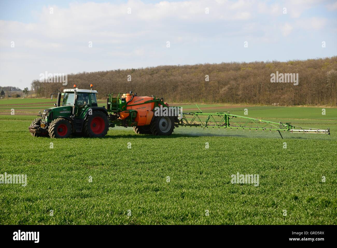 Farmer Spraying Pesticides With Green Tractor On A Field Stock Photo ...