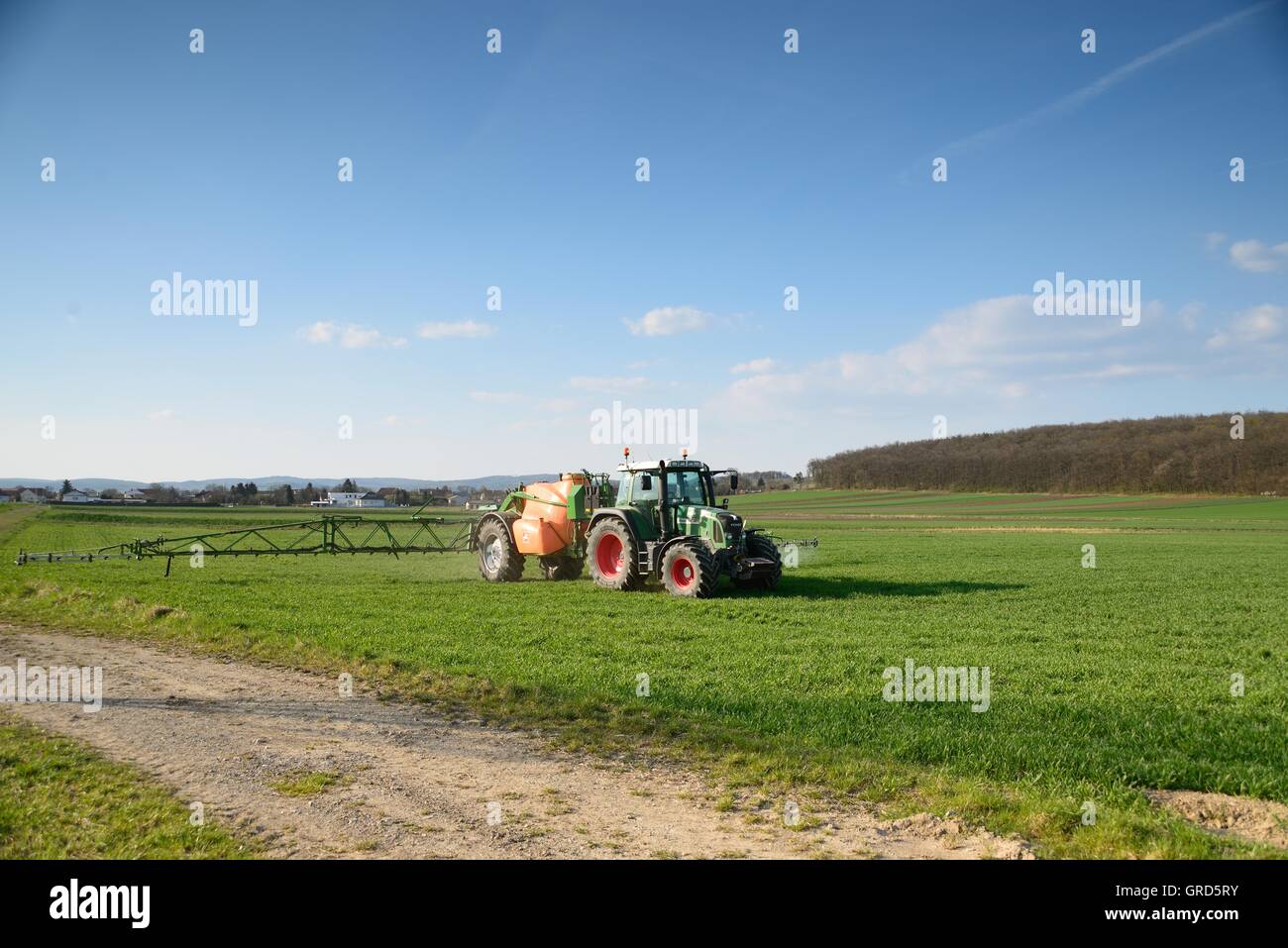 Farmer Spraying Pesticides With Green Tractor On A Field Stock Photo ...