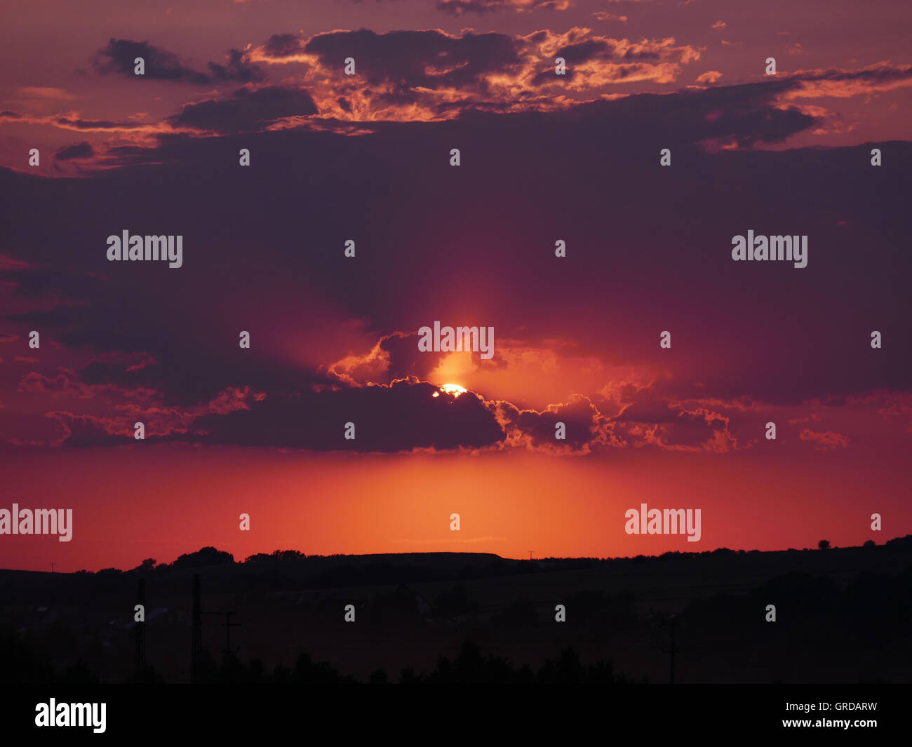 Red evening sun in clouds hi-res stock photography and images - Alamy