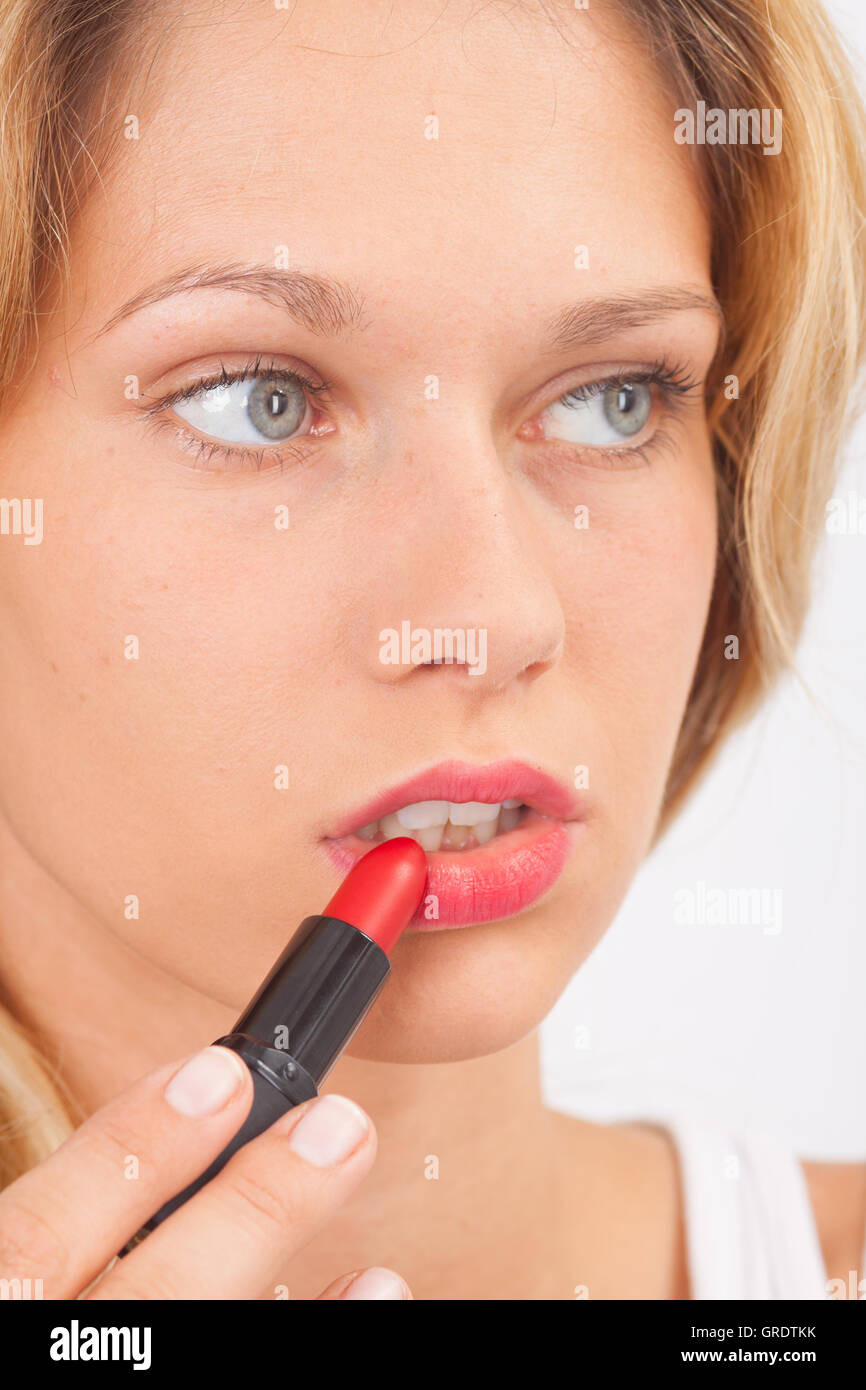 Young Woman In Makeup Mirror, Putting On Lipstick Stock Photo - Alamy