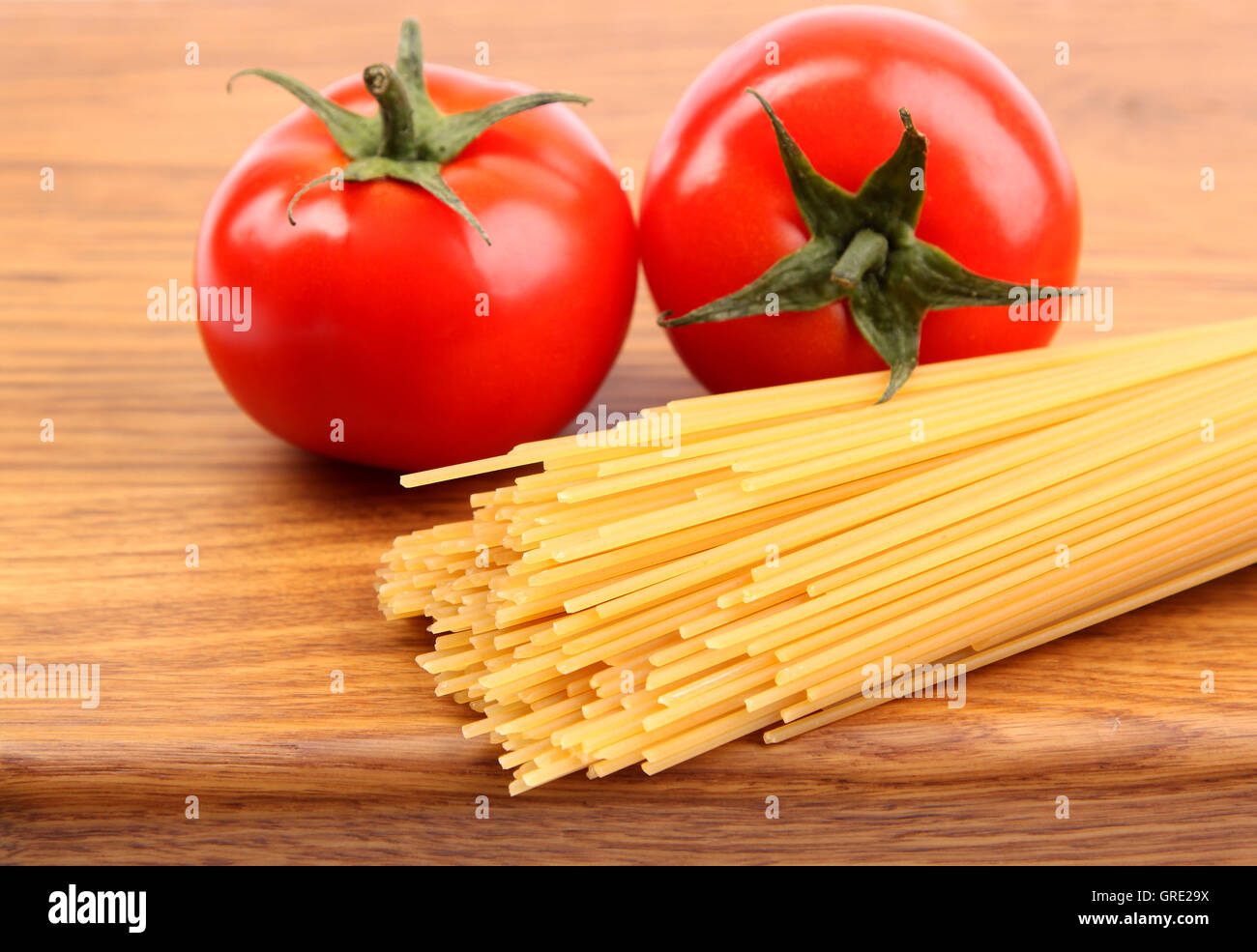 Tomatoesl and uncooked spaghetti Stock Photo - Alamy
