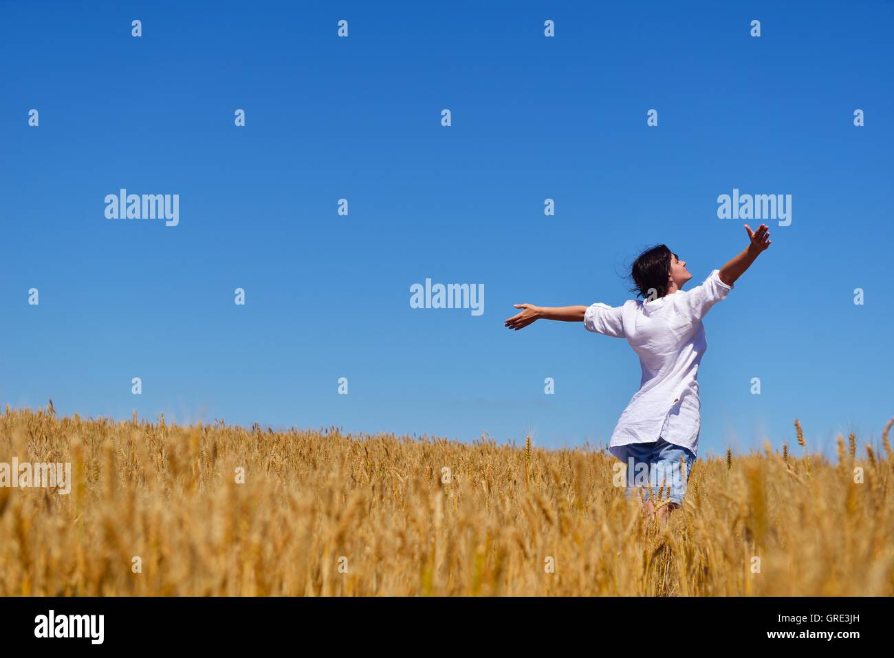 young woman with spreading arms to sky Stock Photo - Alamy