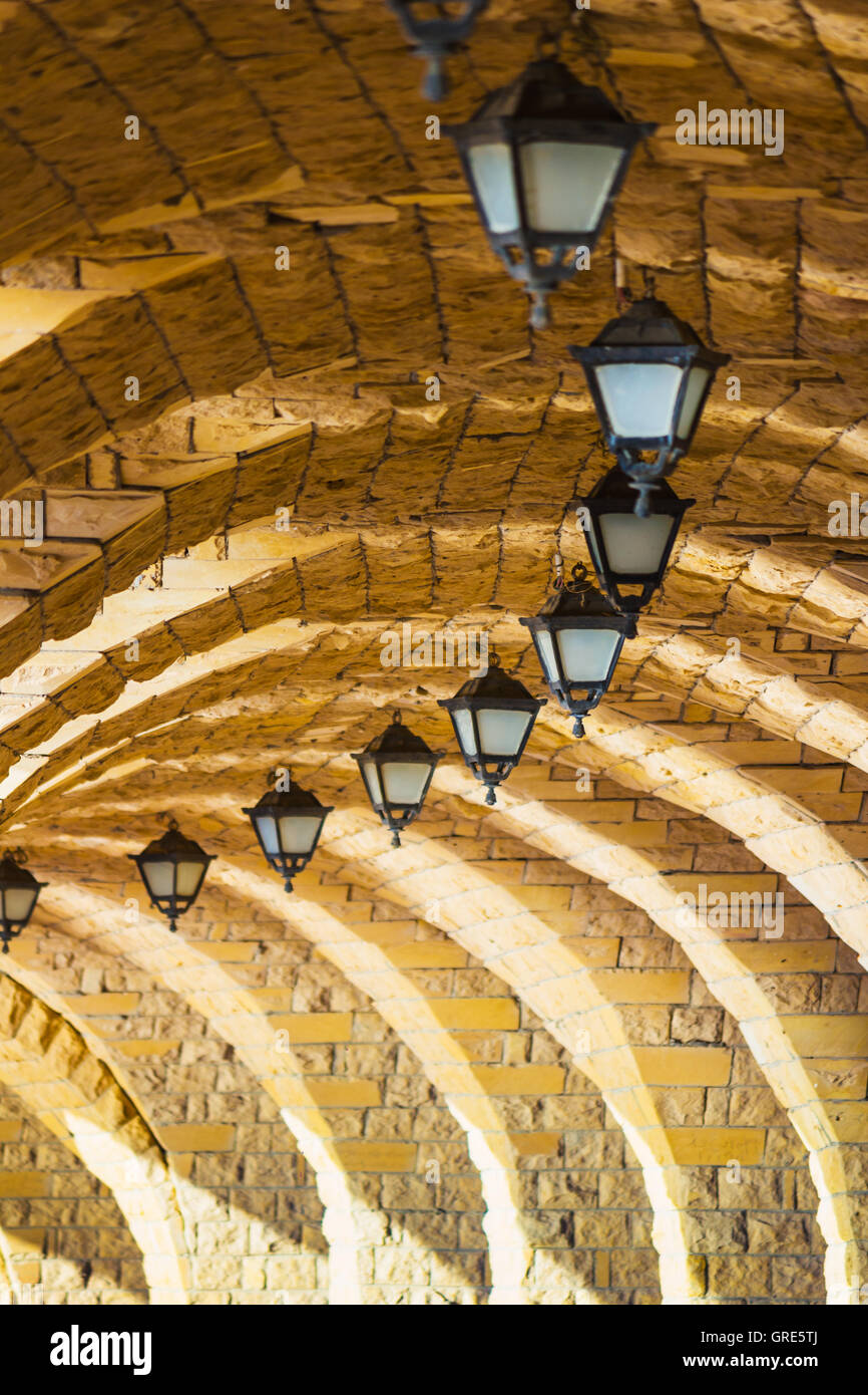 The arched stone colonnade with lanterns Stock Photo - Alamy