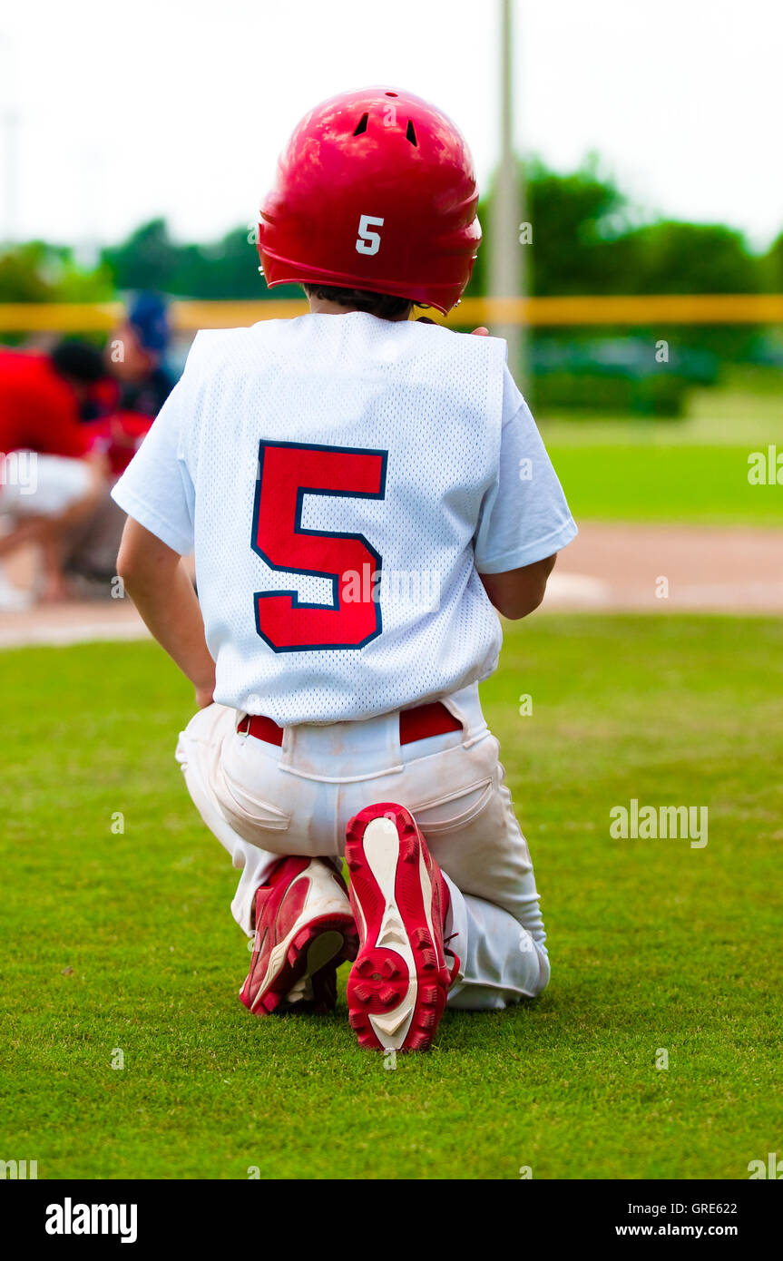 Kneeling baseball boy for injured player Stock Photo - Alamy