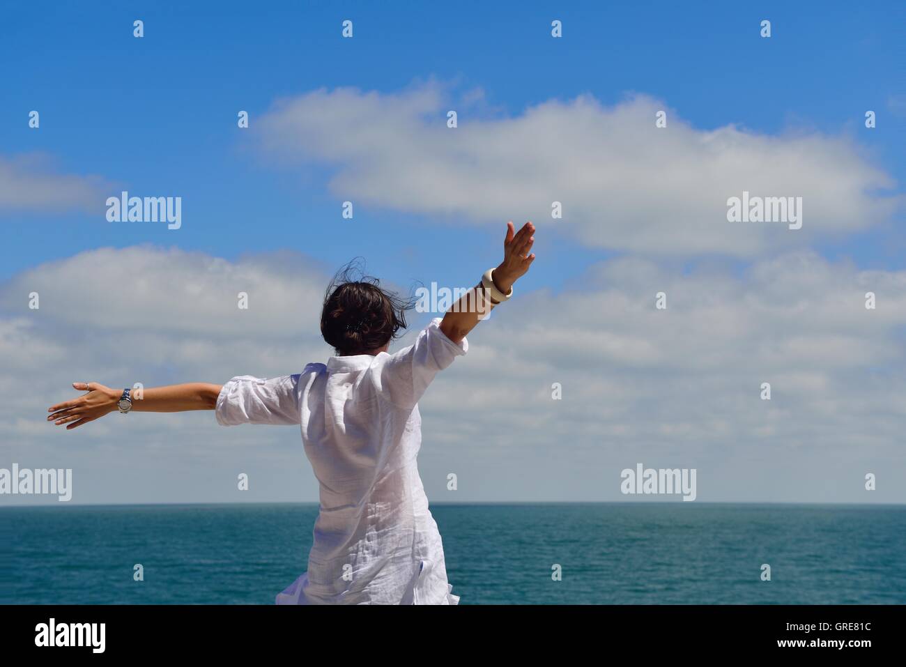 young woman with spreading arms to sky Stock Photo - Alamy