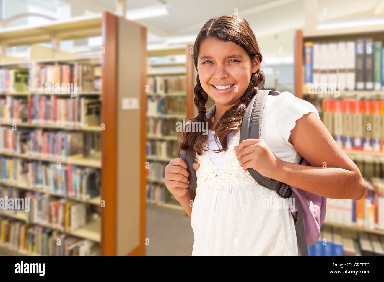 Happy Hispanic Girl Student Wearing Backpack Walking in the Library ...