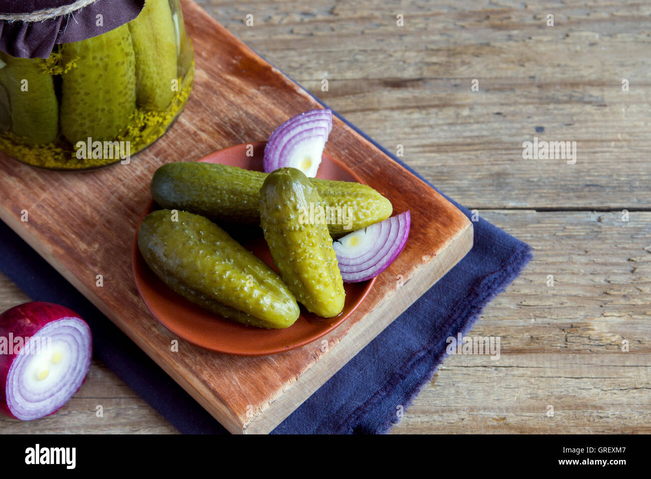 Homemade pickles with red onion over rustic wooden background with copy ...