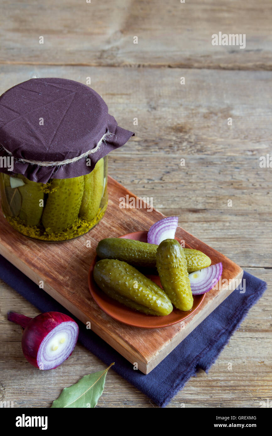 Homemade pickles with red onion over rustic wooden background with copy ...