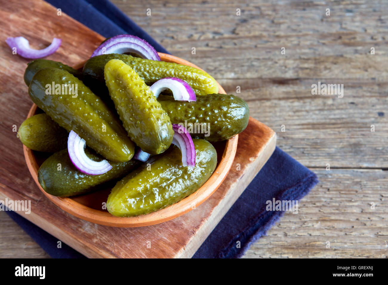 Homemade pickles with red onion over rustic wooden background with copy ...