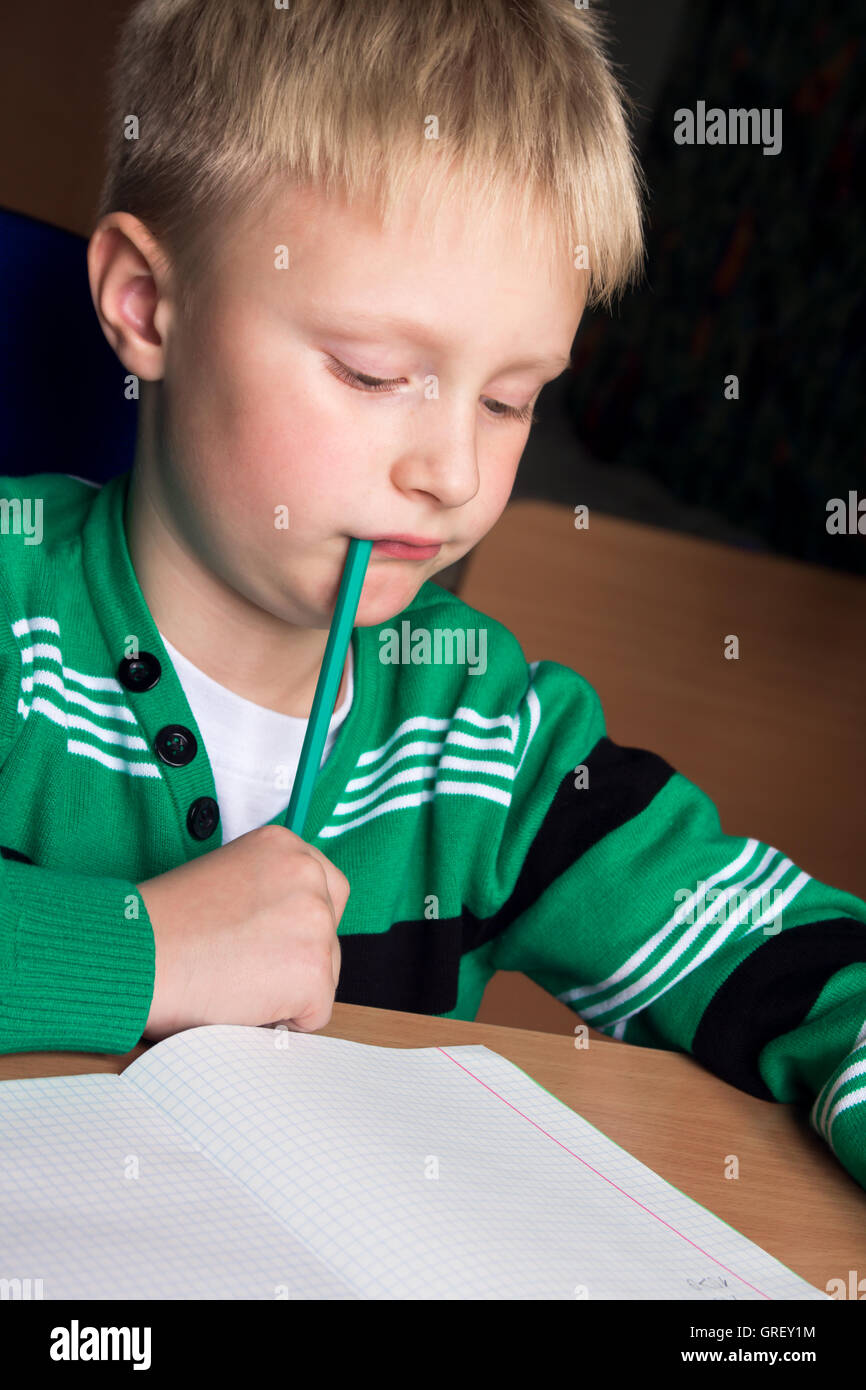 Schoolboy doing his difficult school homework with problems Stock Photo ...