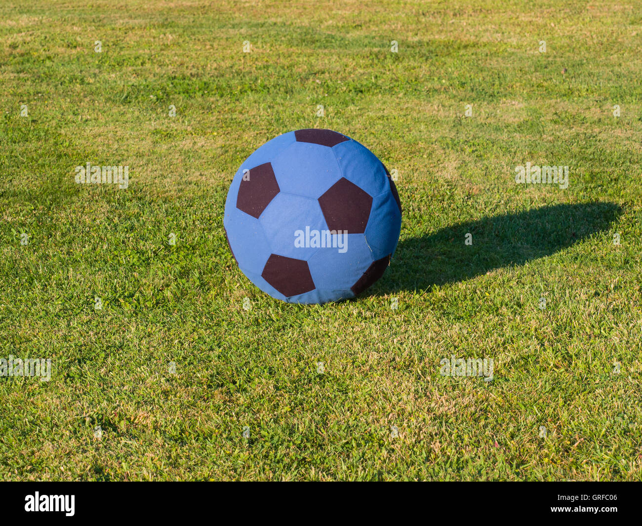 big blue and black soft soccer ball on the grass of a field Stock Photo ...