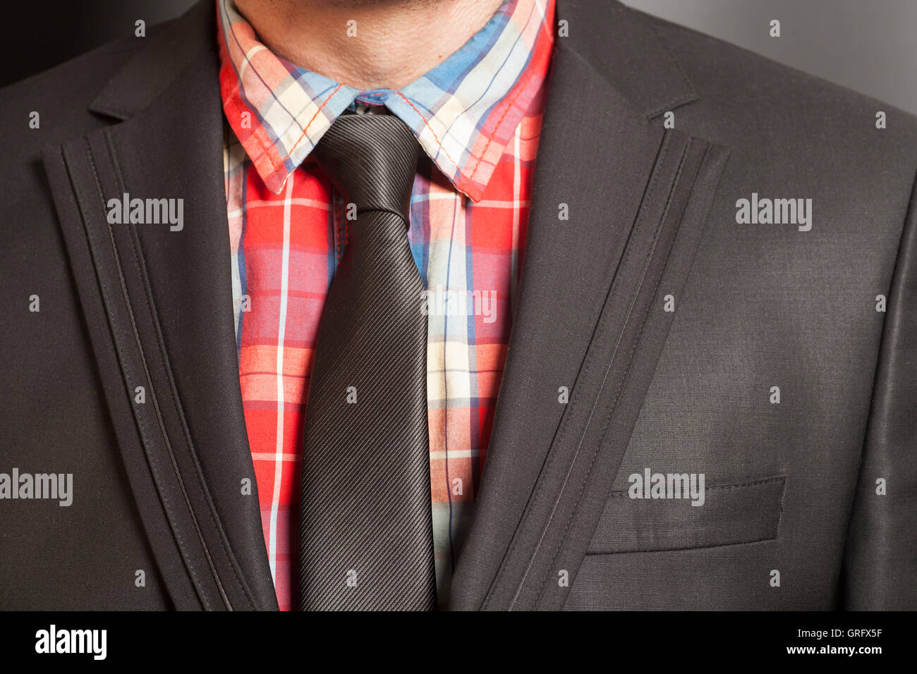 Man in black suit and black tie on a black background Stock Photo - Alamy