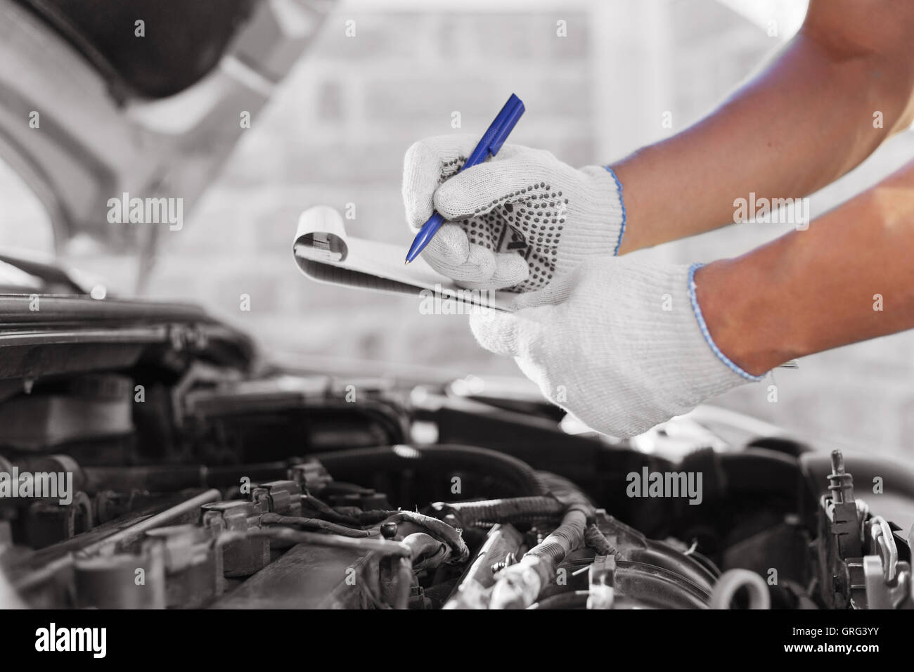 Auto mechanic checking car engine at the garage Stock Photo - Alamy