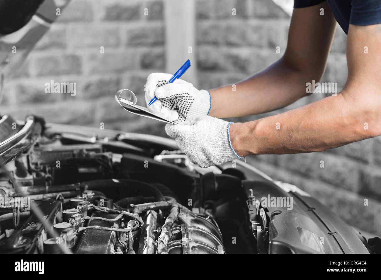 Auto mechanic checking car engine at the garage Stock Photo - Alamy