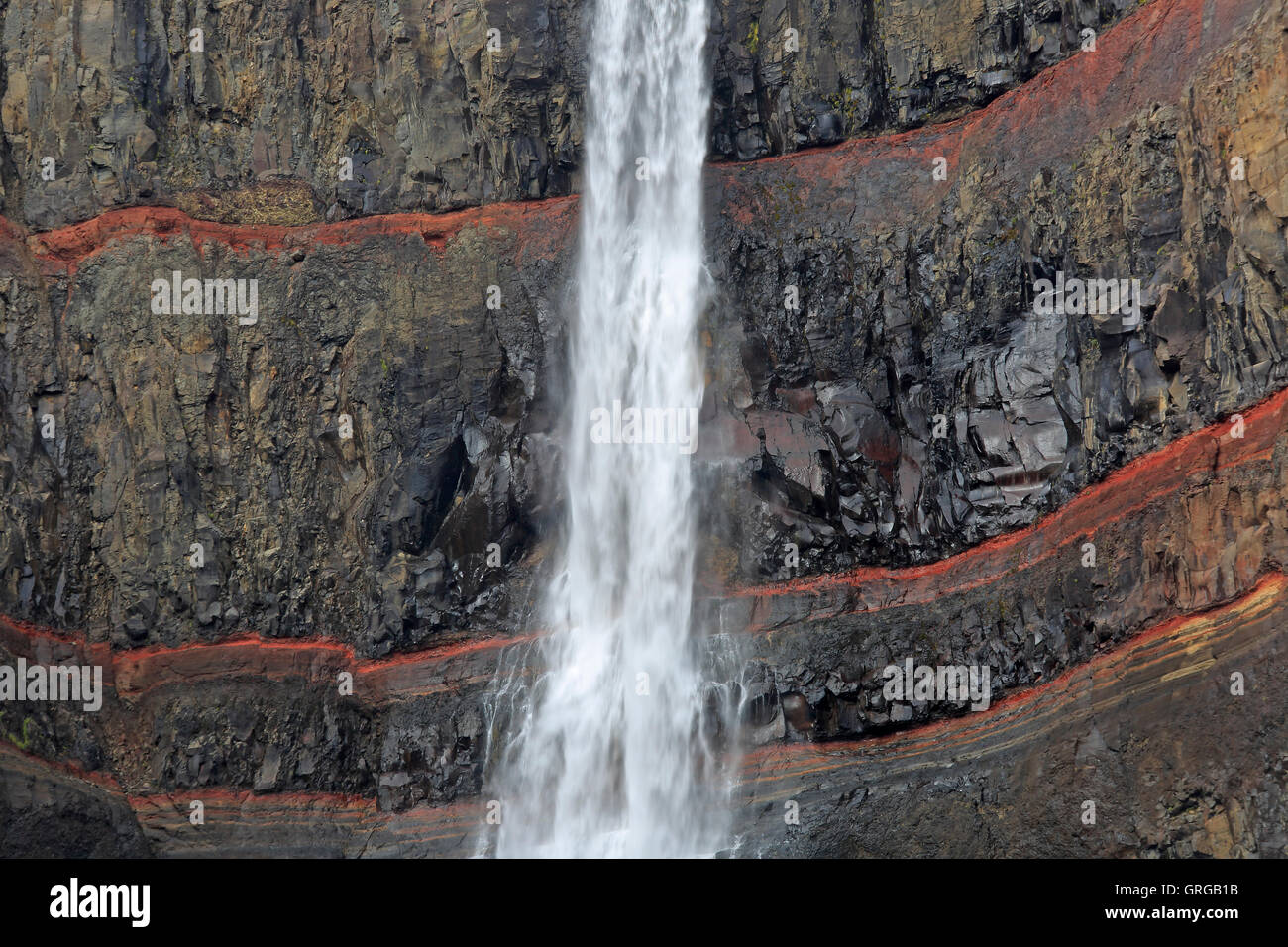 Hengifoss waterfall showing the red deposits in the cliff Stock Photo ...