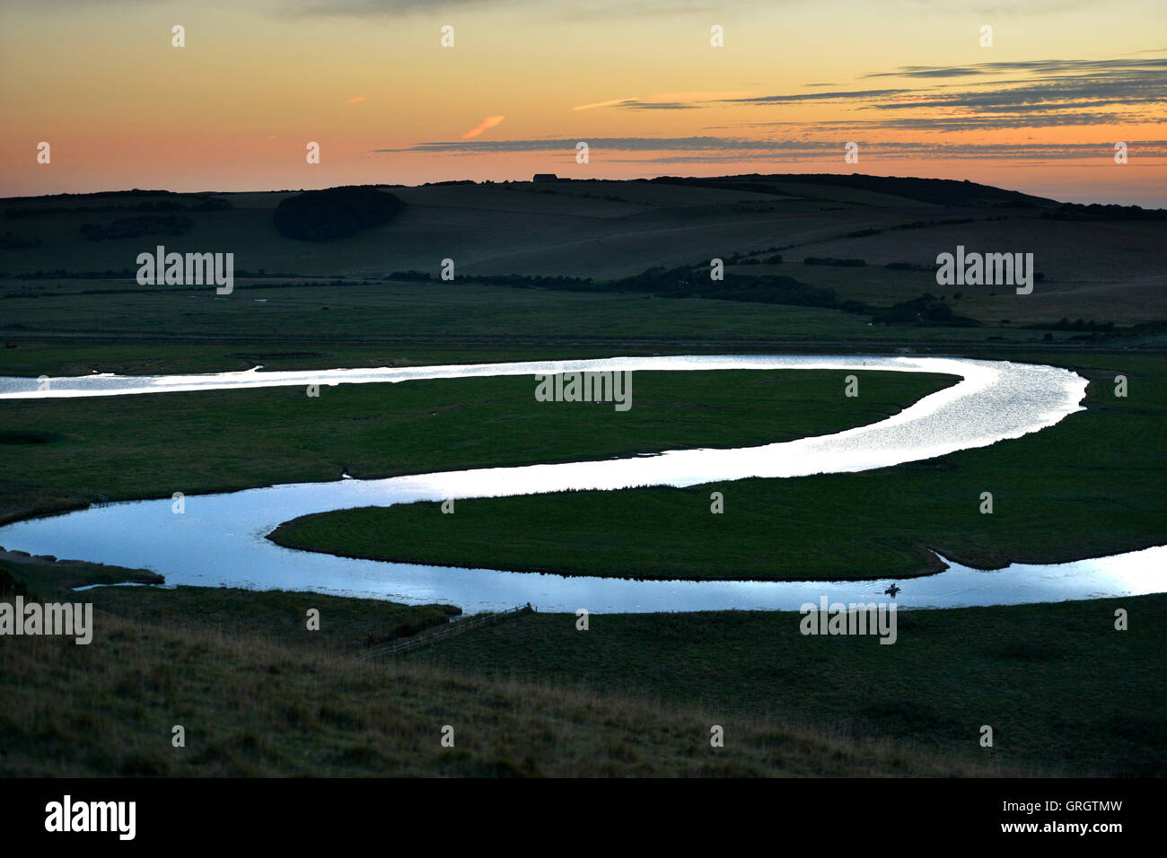 River Cuckmere, East Sussex, UK. Canoeist enjoying paddling at sunset ...