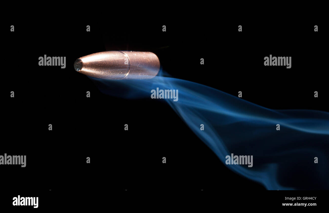 Bronze colored bullet with lots of smoke trailing behind Stock Photo ...