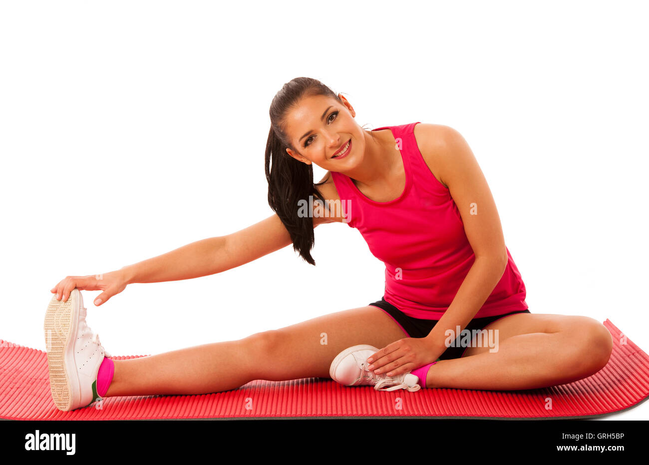 fit woman stretches body after workout in fitness gym isolated over ...