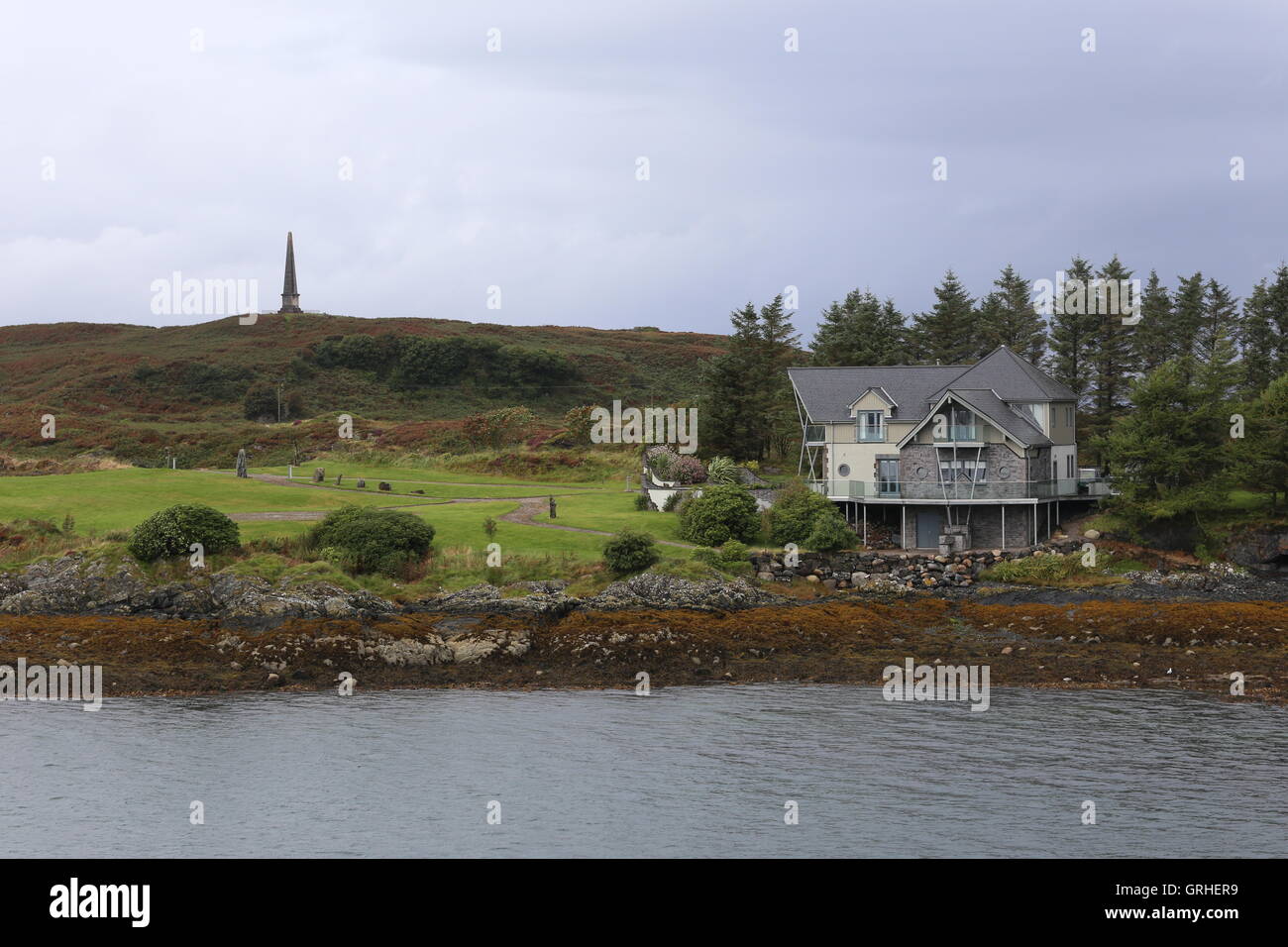 Waterfront house and Hutcheson's monument Isle of Kerrera Scotland ...