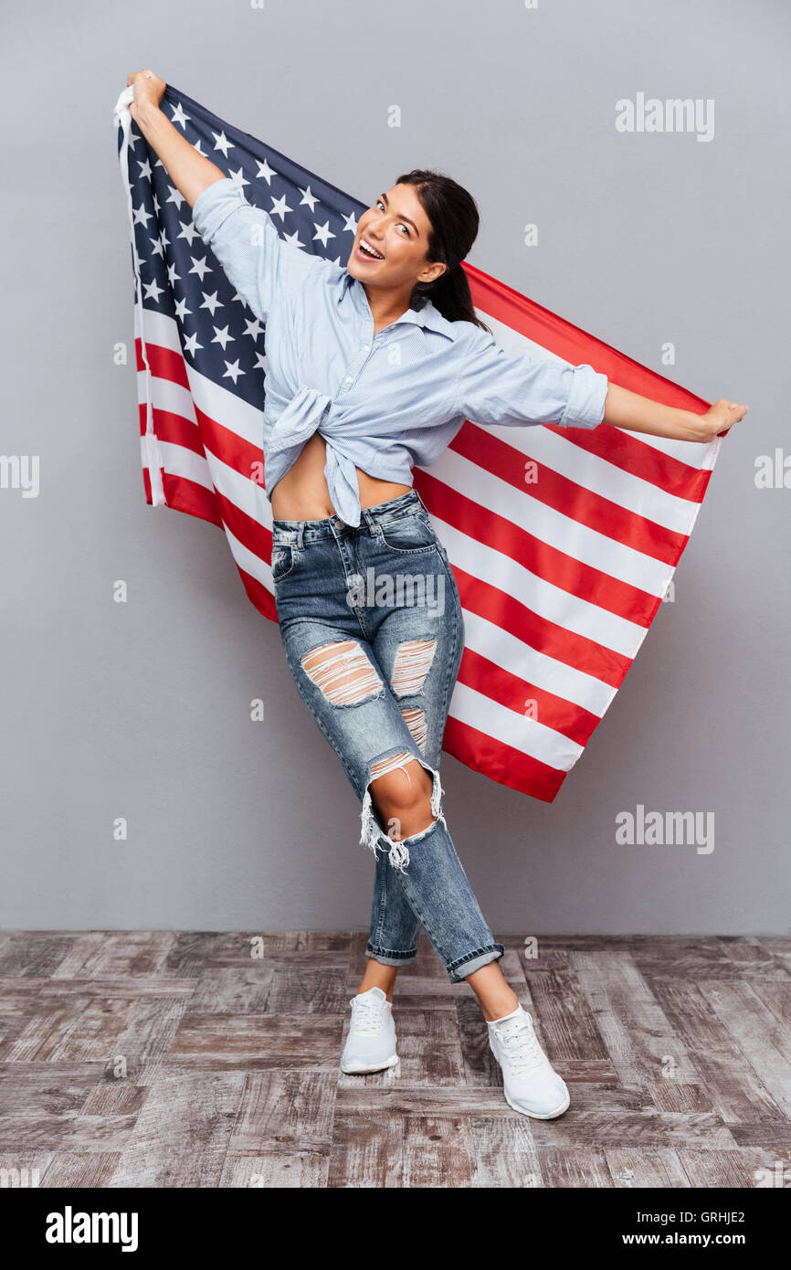 Cheerful young happy girl holding USA flag over gray background Stock ...