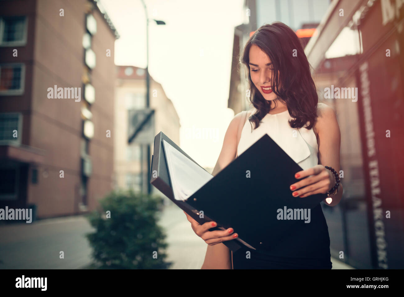 Businesswoman reading outside while walking Stock Photo - Alamy