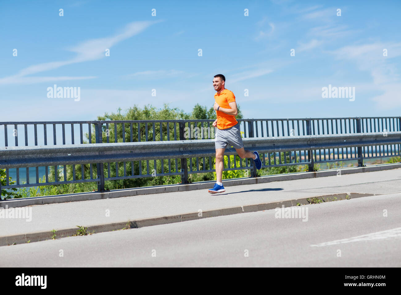 smiling young man running at summer seaside Stock Photo - Alamy