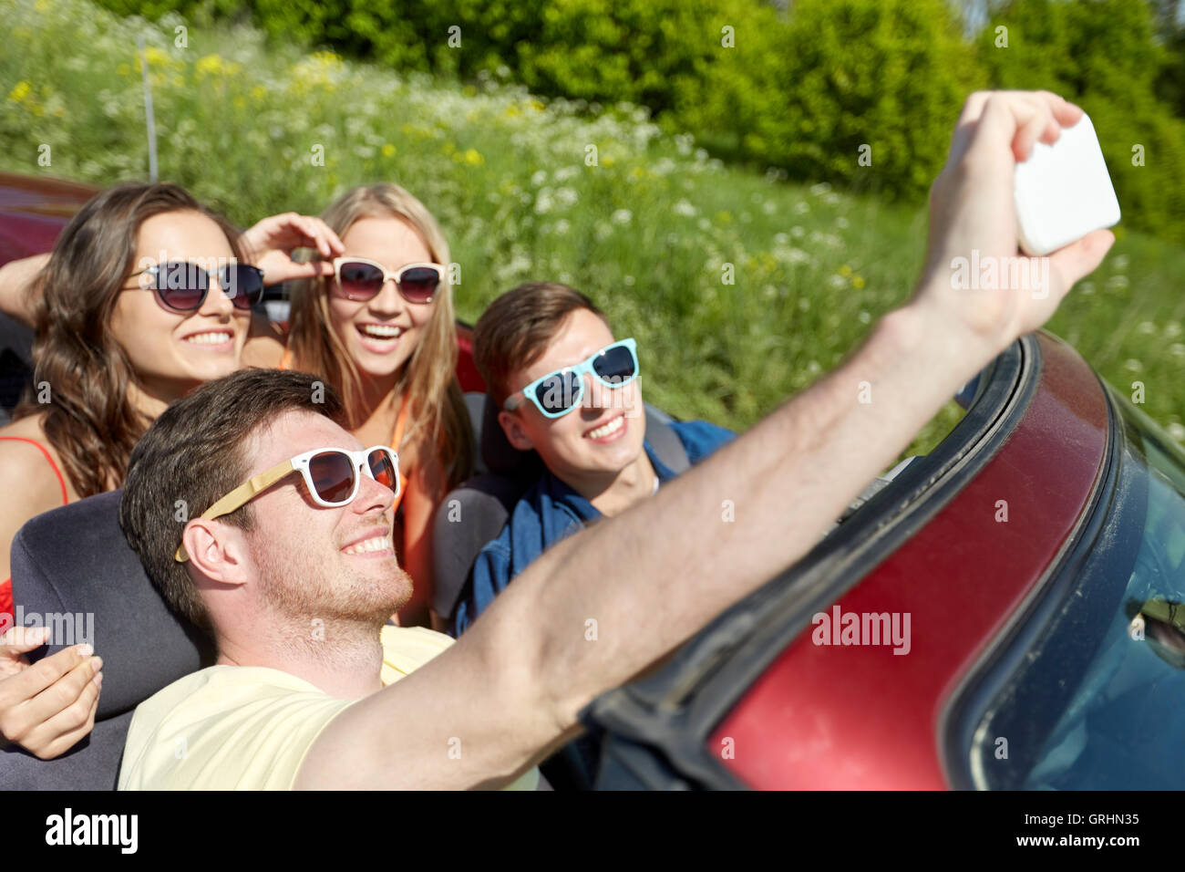friends driving in cabriolet car and taking selfie Stock Photo - Alamy