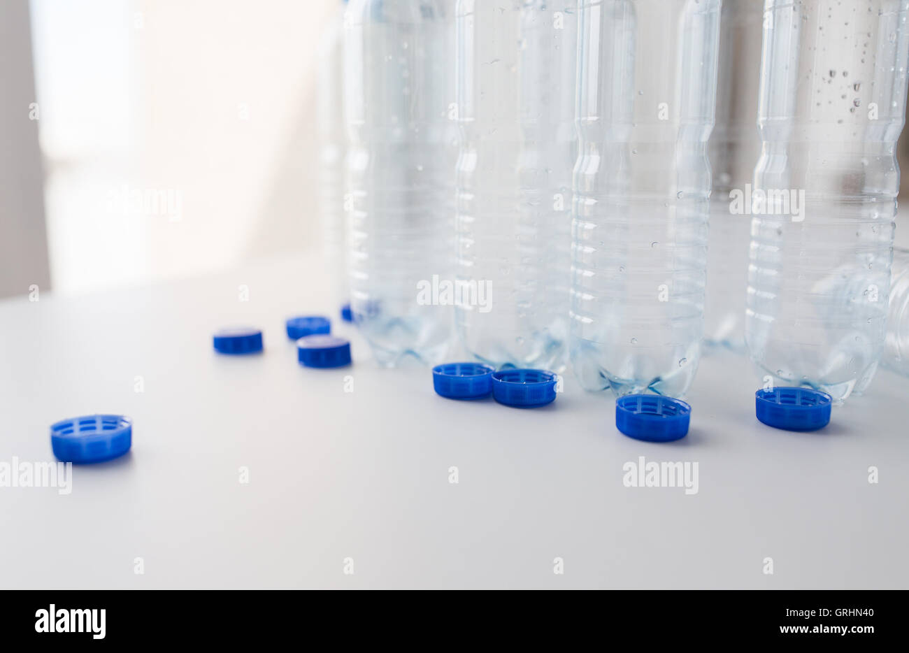 close up of empty water bottles and caps on table Stock Photo - Alamy
