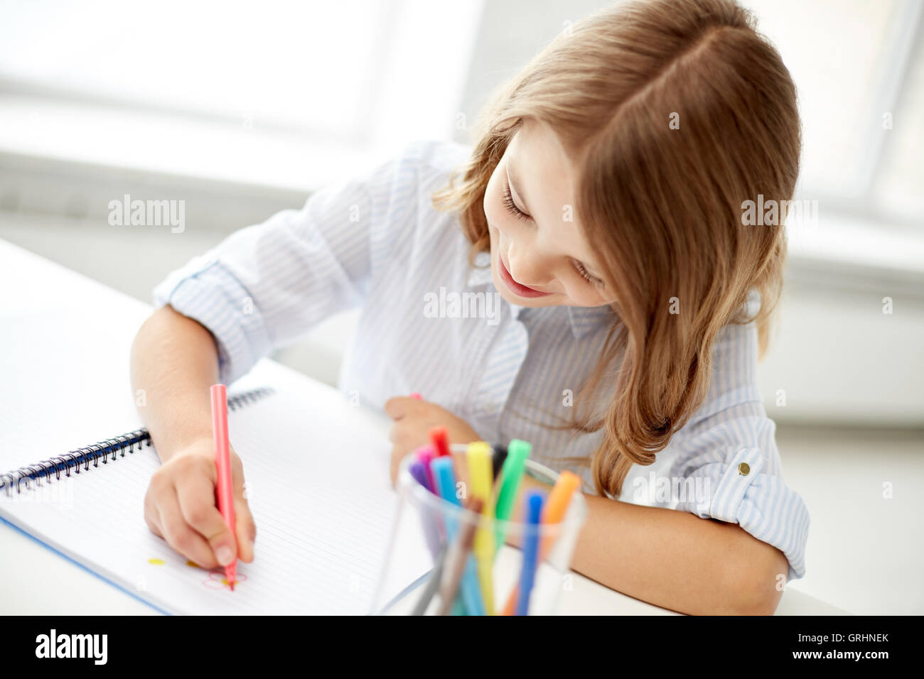 happy girl drawing with felt-tip pen in notebook Stock Photo - Alamy
