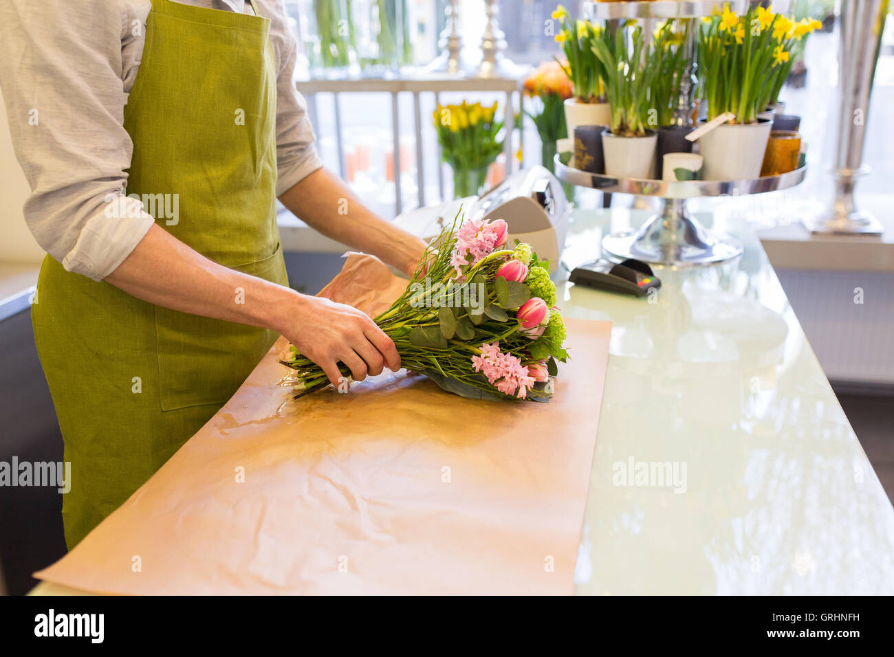 florist wrapping flowers in paper at flower shop Stock Photo - Alamy