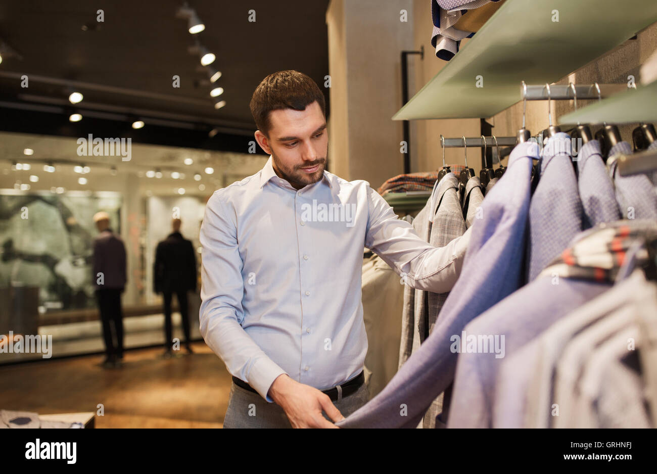 happy young man choosing clothes in clothing store Stock Photo - Alamy