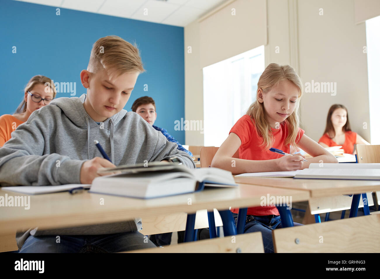 group of students with books writing school test Stock Photo - Alamy