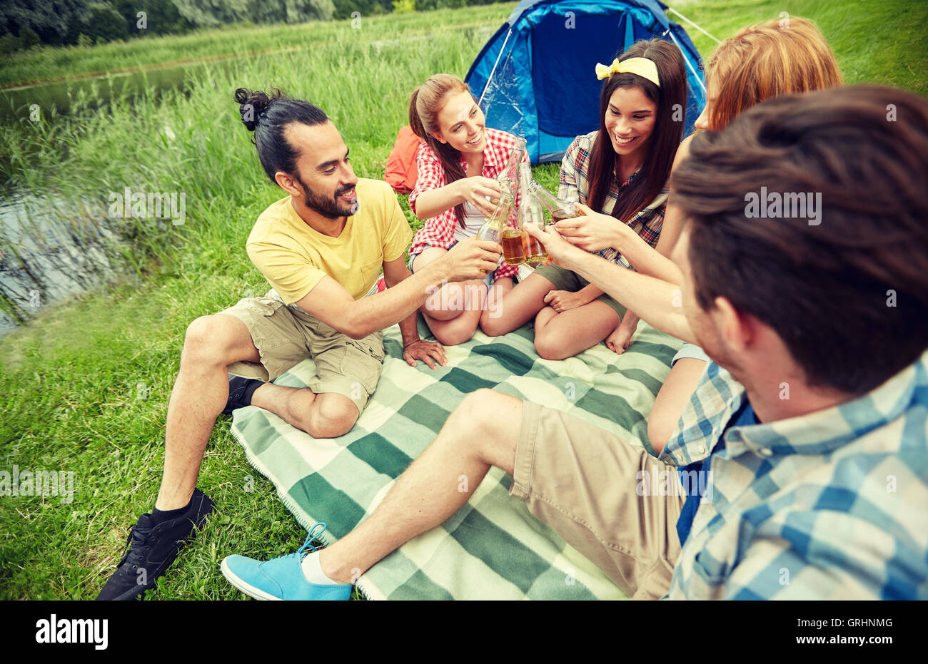 happy friends with tent and drinks at campsite Stock Photo - Alamy