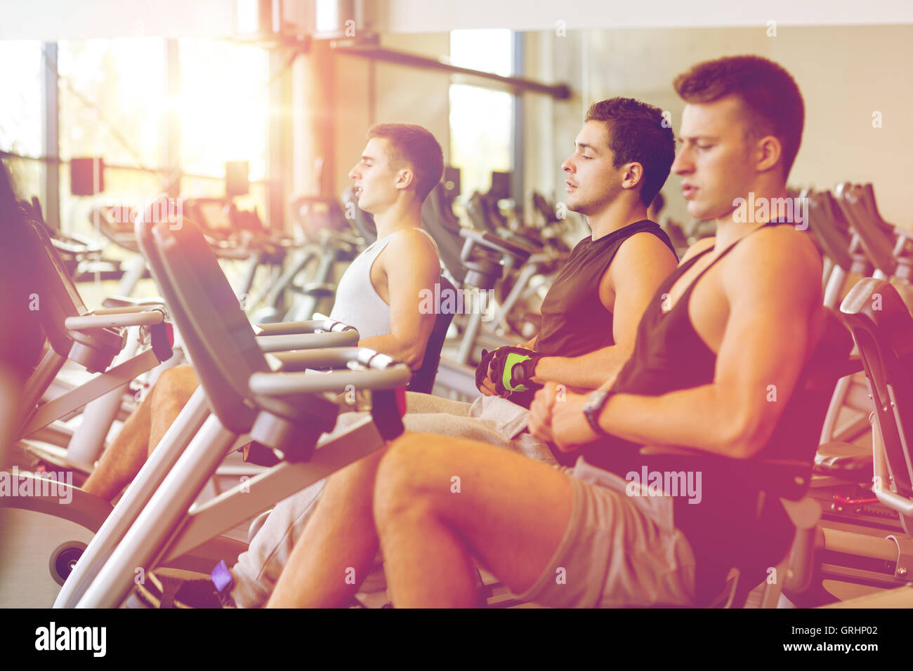 men working out on exercise bike in gym Stock Photo - Alamy